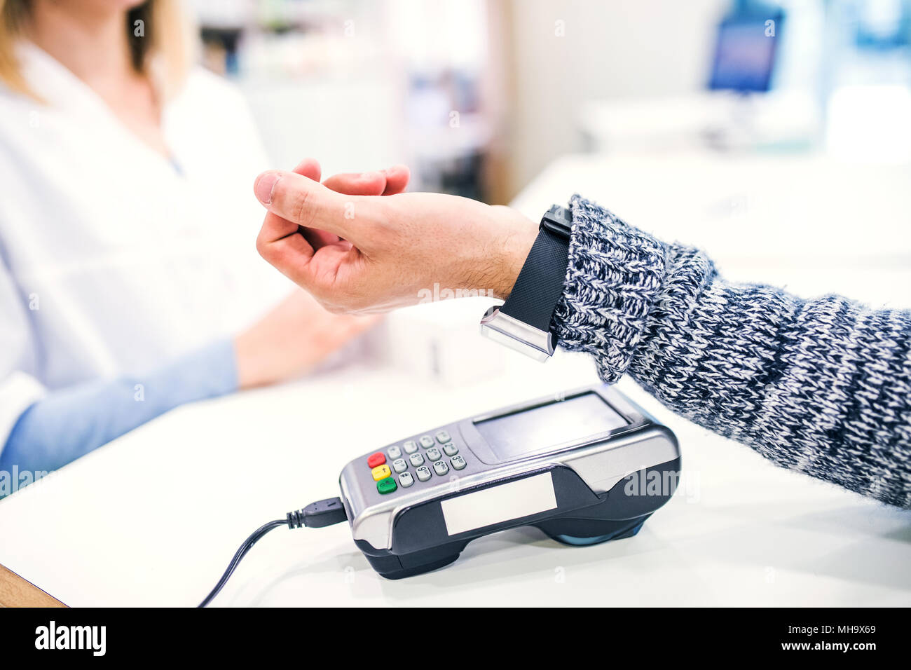 A customer making wireless or contactless payment using smartwatch ...