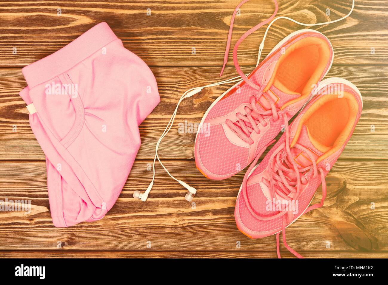 Pink sneakers on wooden texture Stock Photo - Alamy