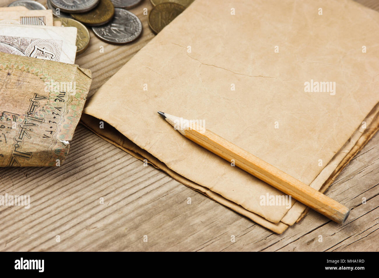 Old notes and coins and pencil on a wooden table Stock Photo - Alamy