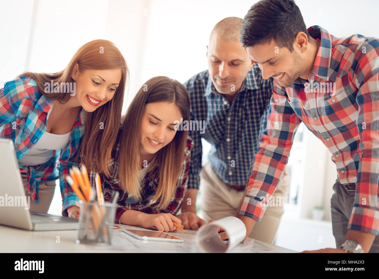 Successful young design team discussing construction plans and planning ...