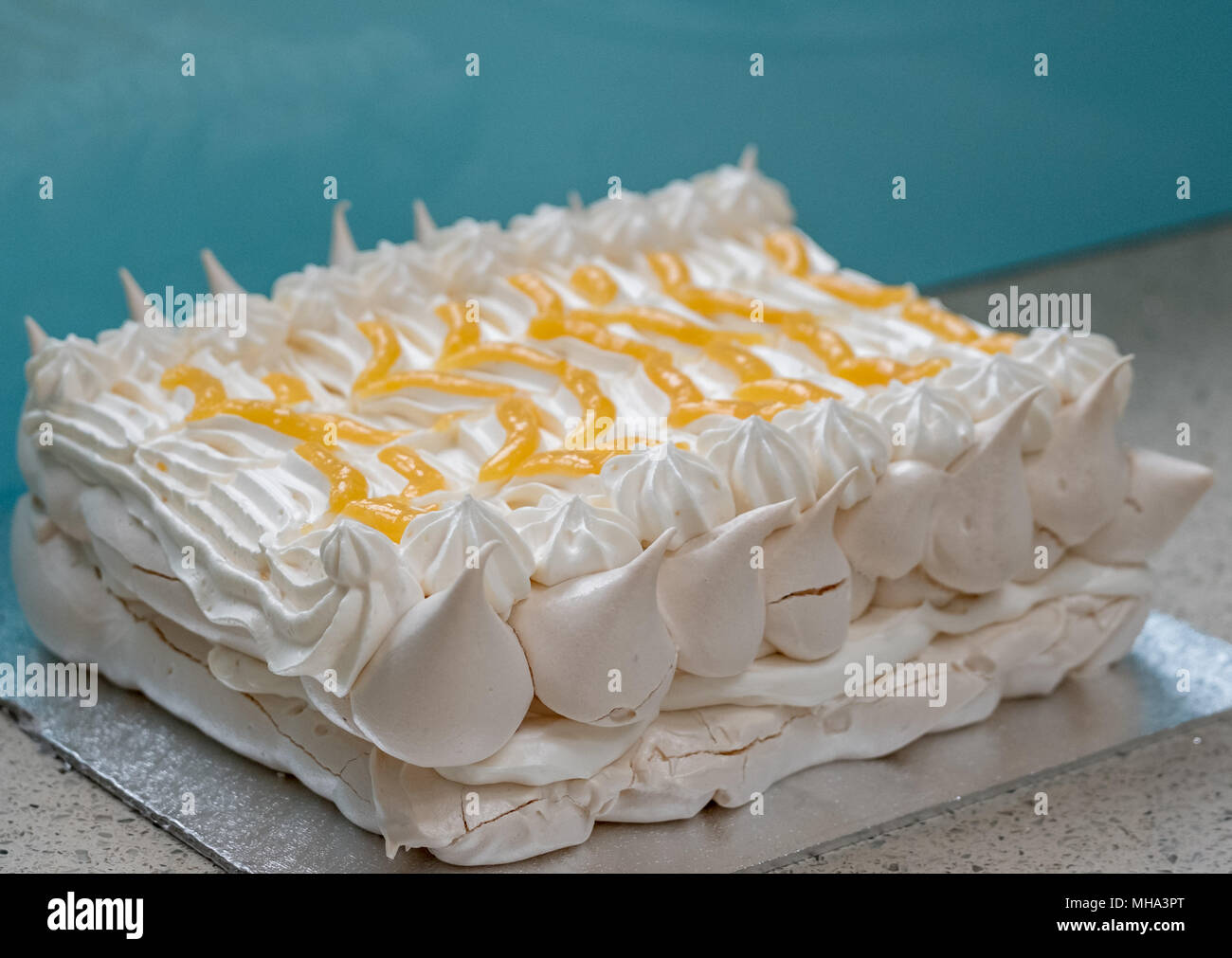 Piped meringue pavlova cake decorated with cream and lemon curd in a ...
