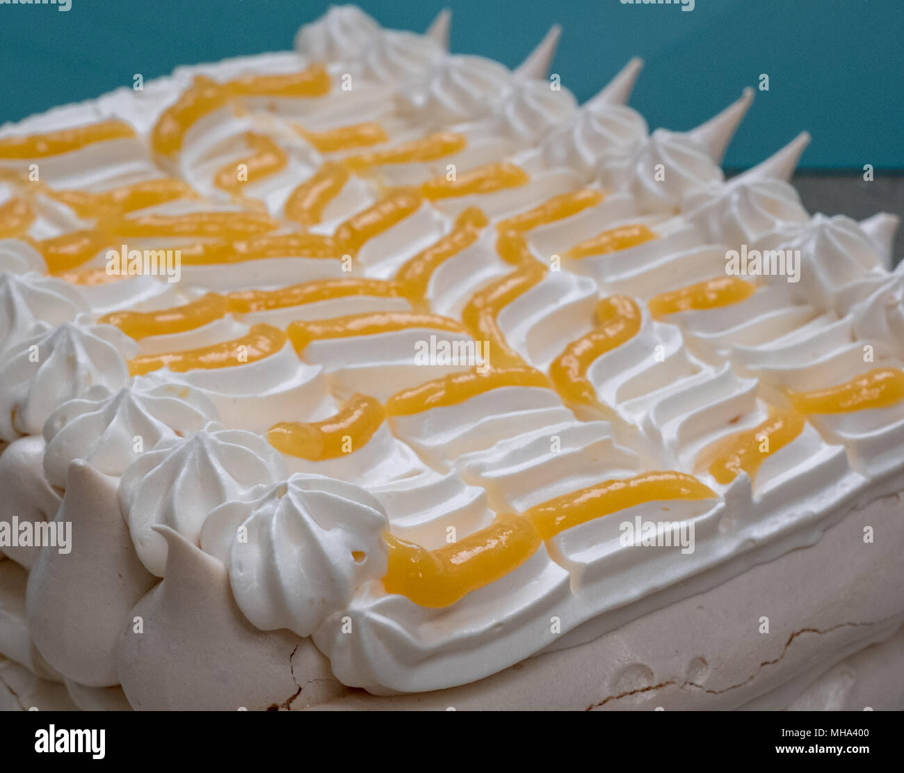 Piped meringue pavlova cake decorated with cream and lemon curd in a ...