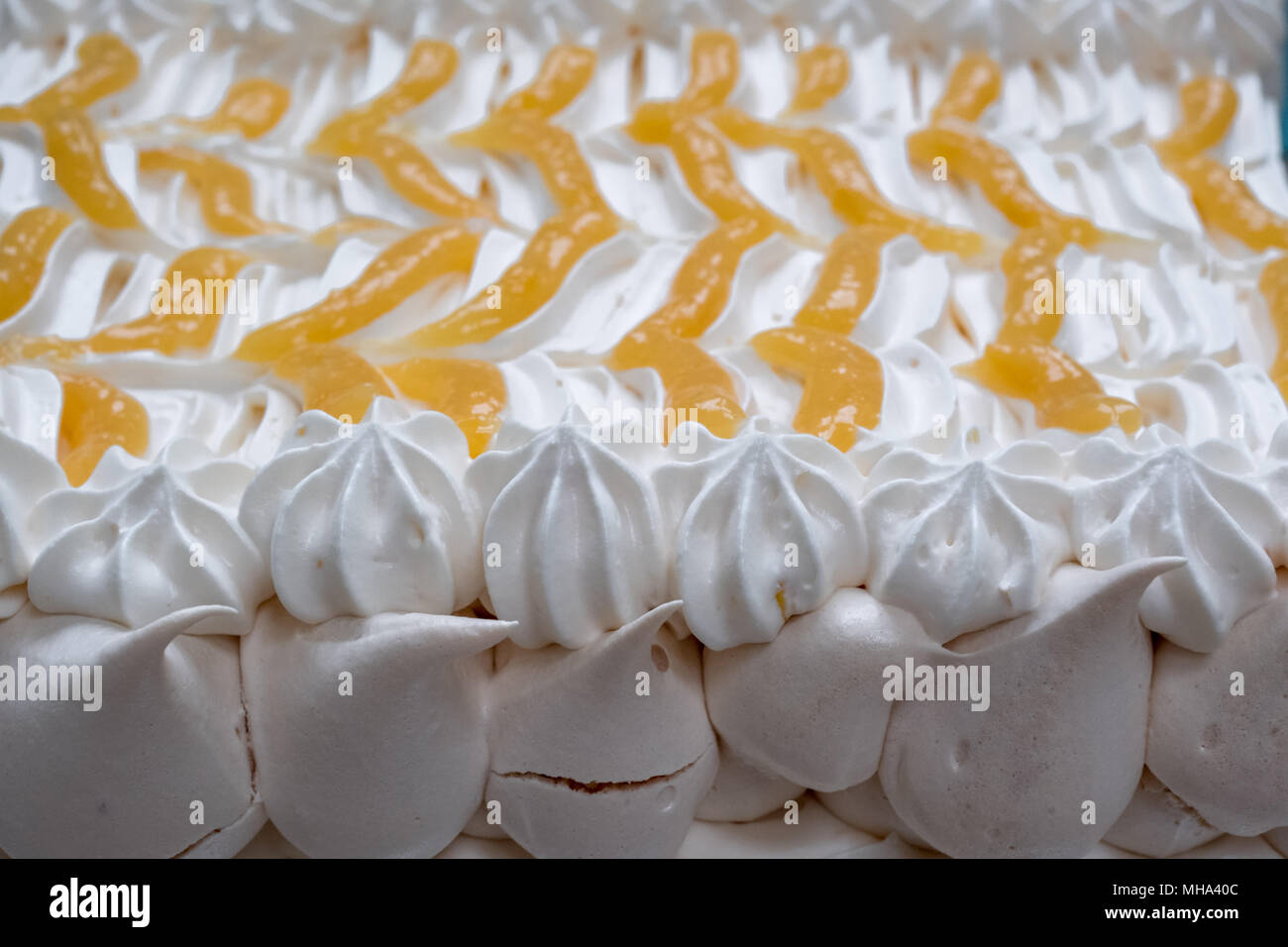Piped meringue pavlova cake decorated with cream and lemon curd in a ...