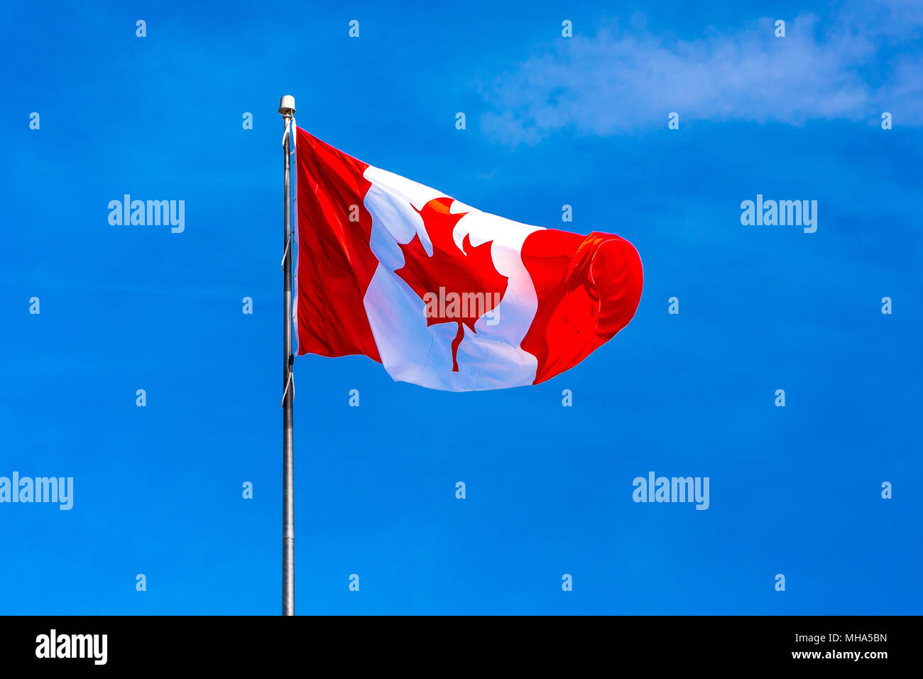 Flag of Canada flying against a blue sky. North America Stock Photo - Alamy