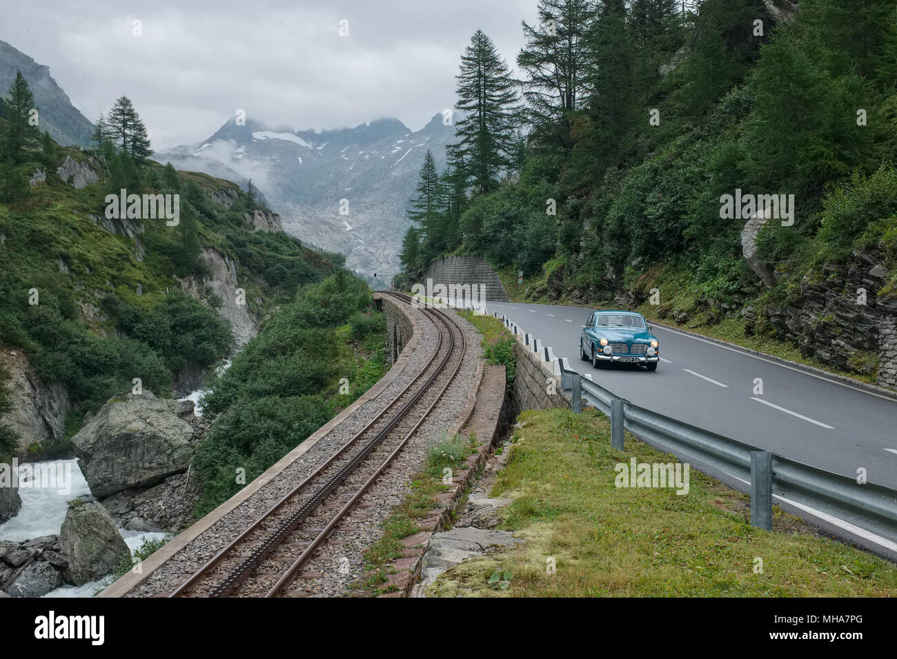 Volvo oldtimer car driving on a mountain pass in the Swiss Alps near ...