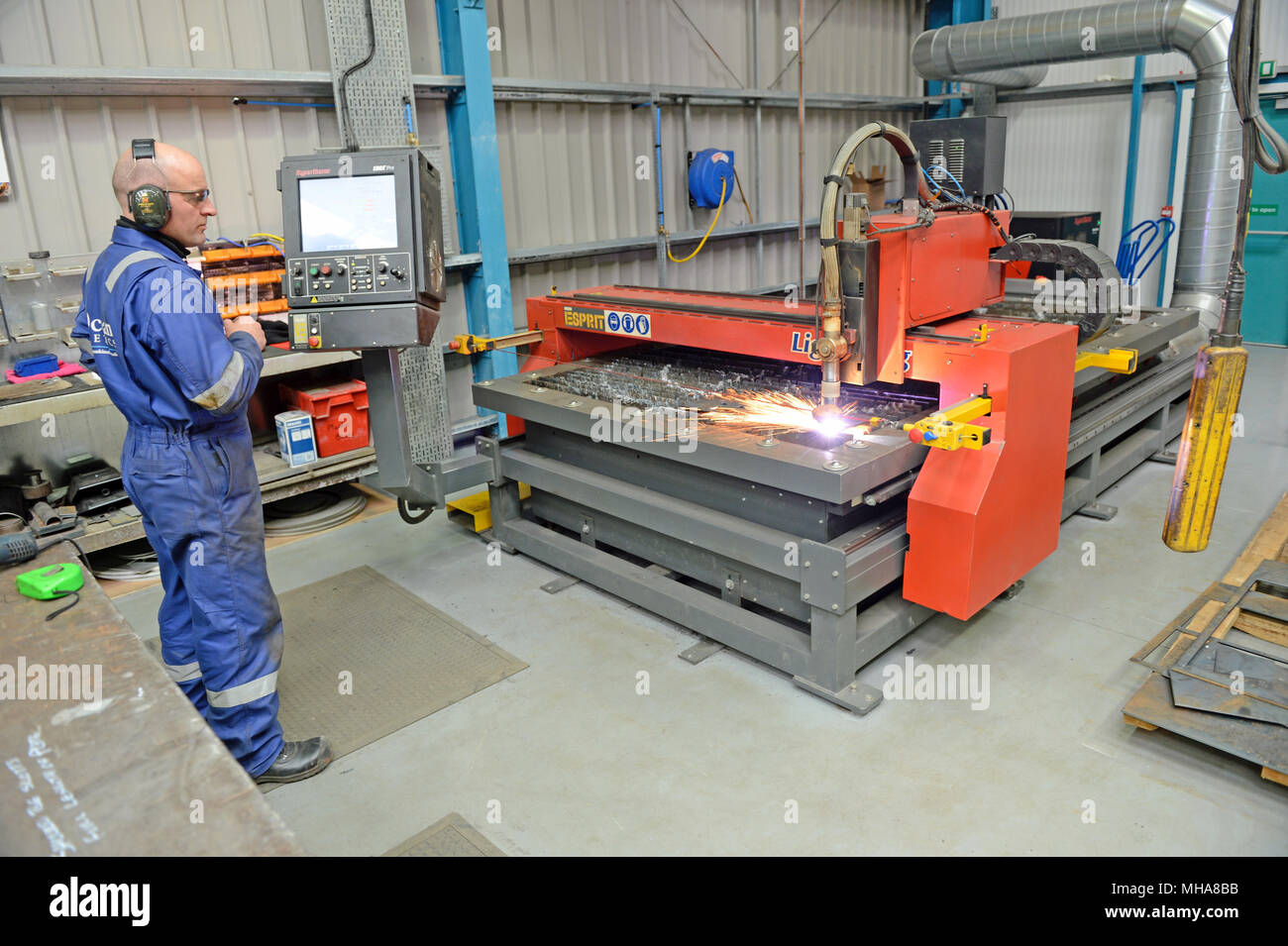 Man working on a metal plasma cutting machine in an engineering ...