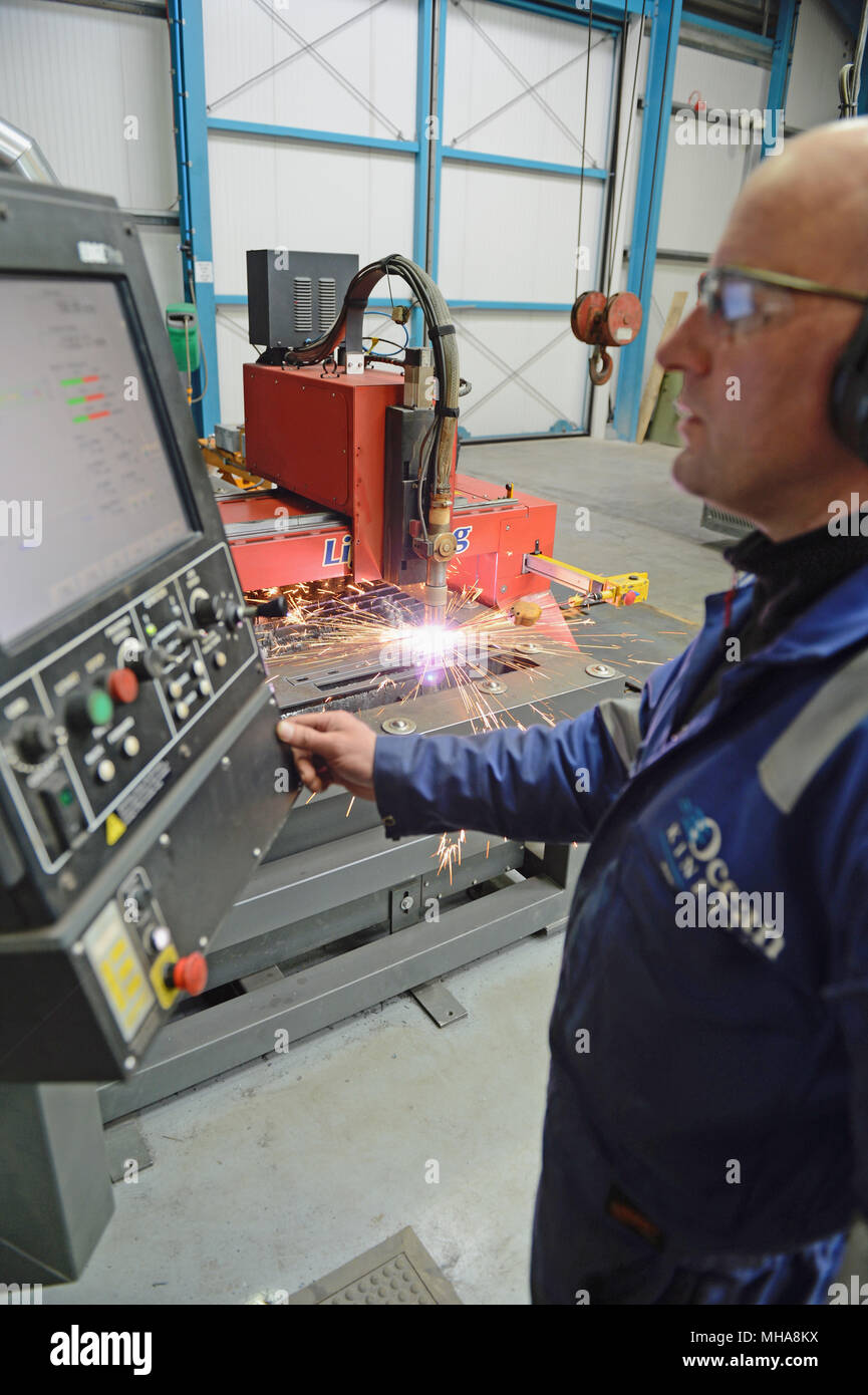Man working on a metal plasma cutting machine in an engineering ...