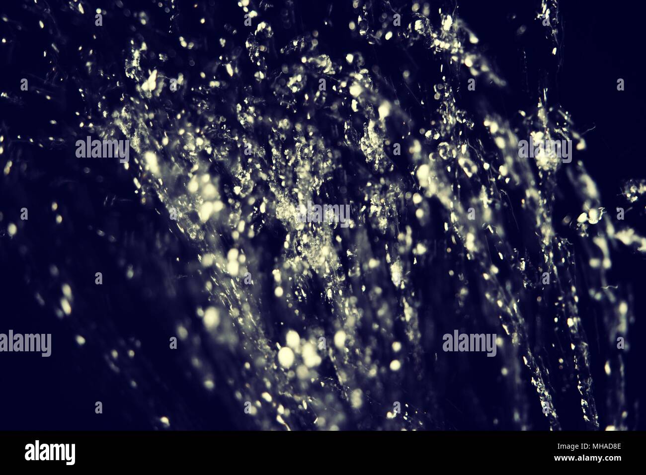 Water drops fly in the air on dark background Stock Photo - Alamy