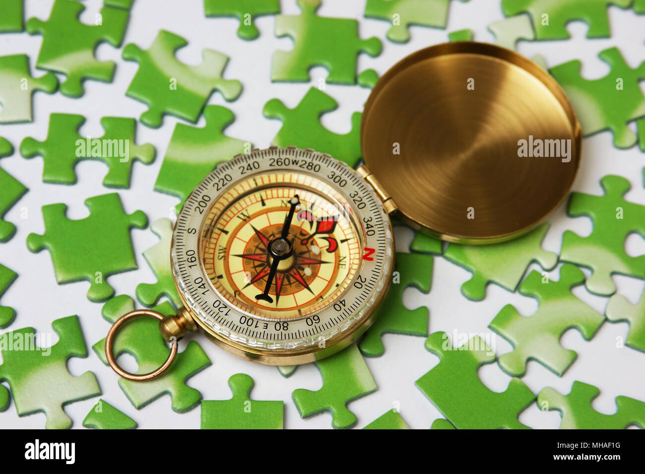 compass on the green puzzle Stock Photo - Alamy