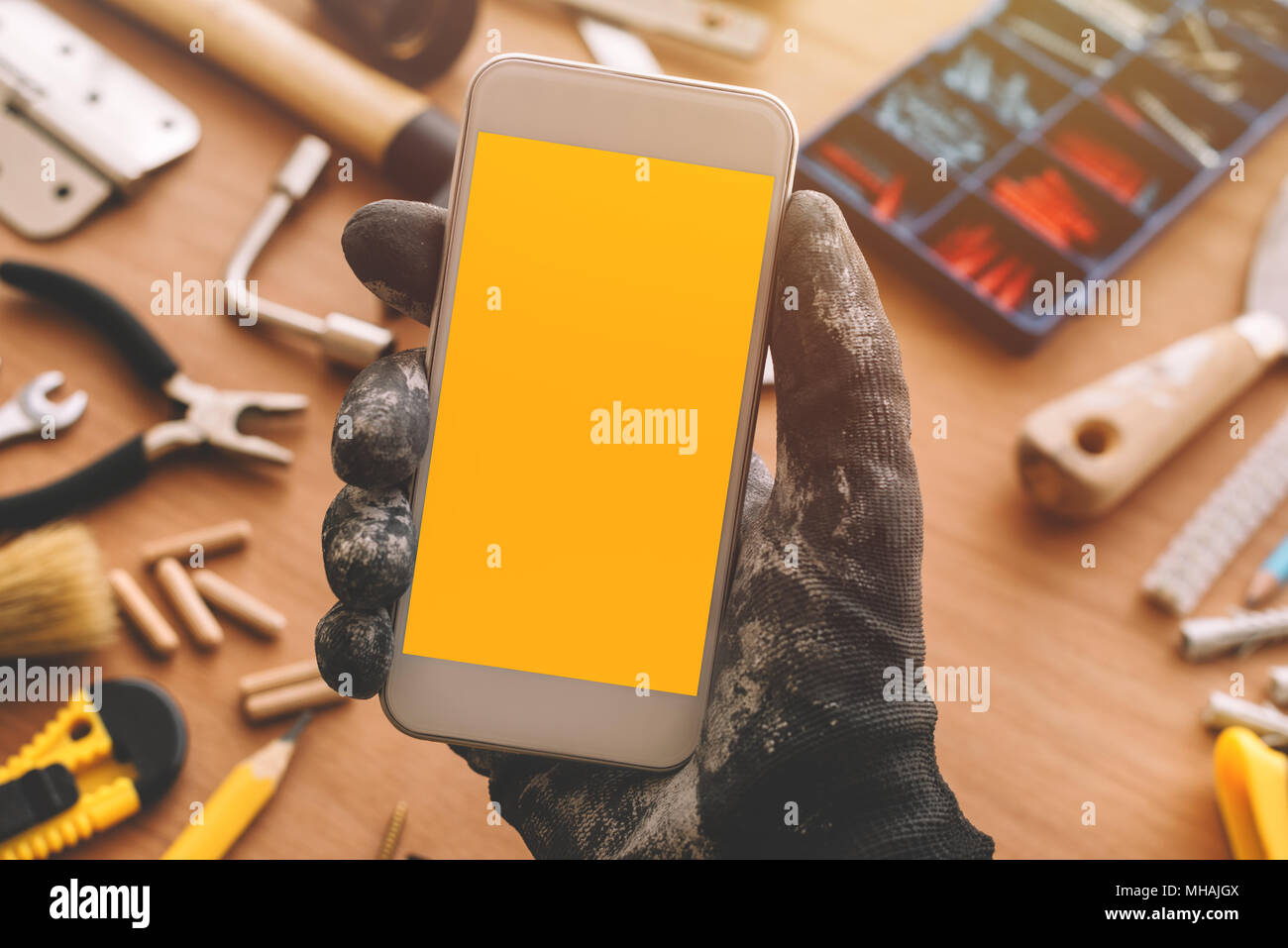 Repairman smart phone app with blank screen. Handyman holding telephone ...