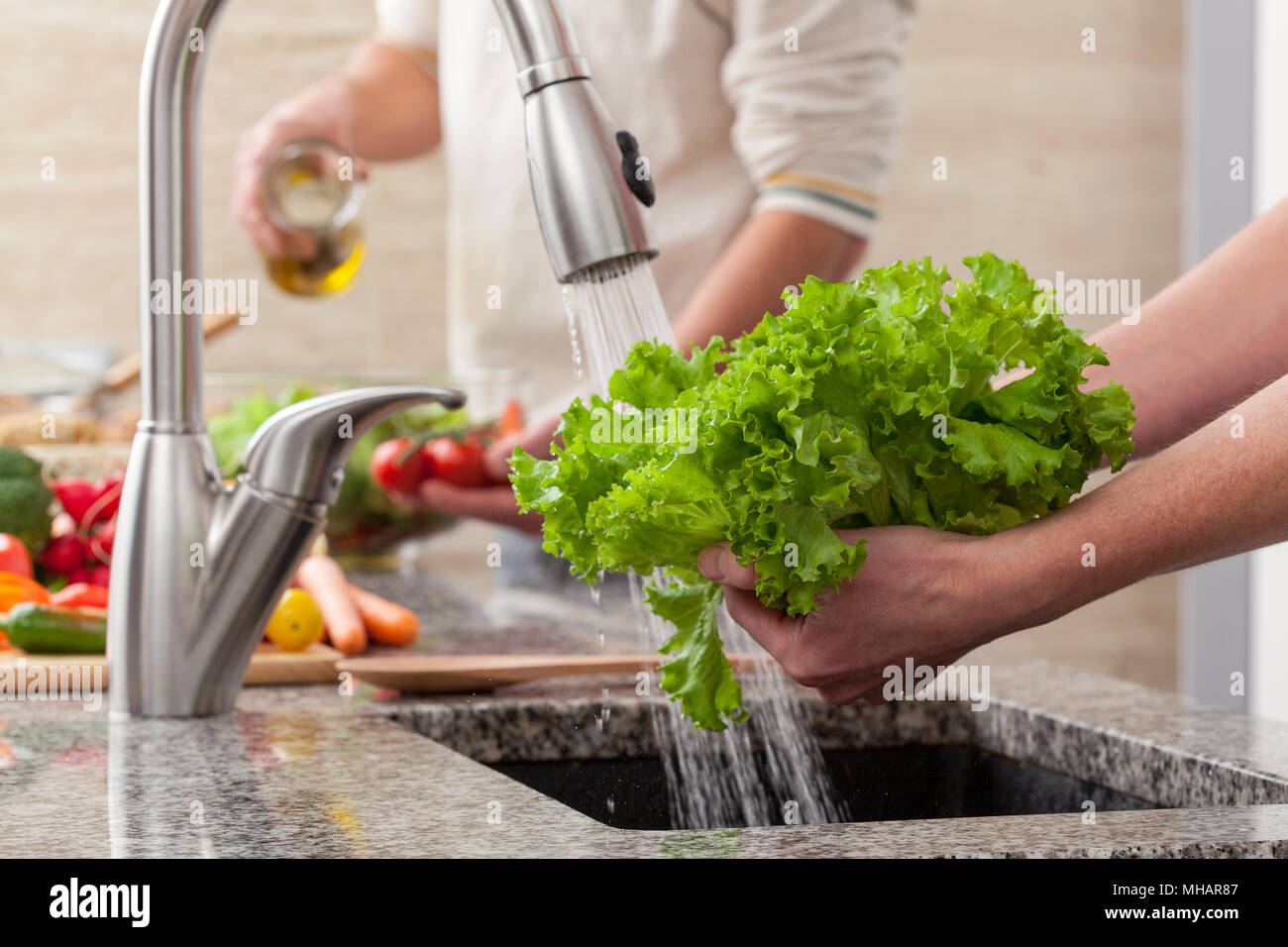Washing fresh vegetables for a salad with an alive oil Stock Photo - Alamy
