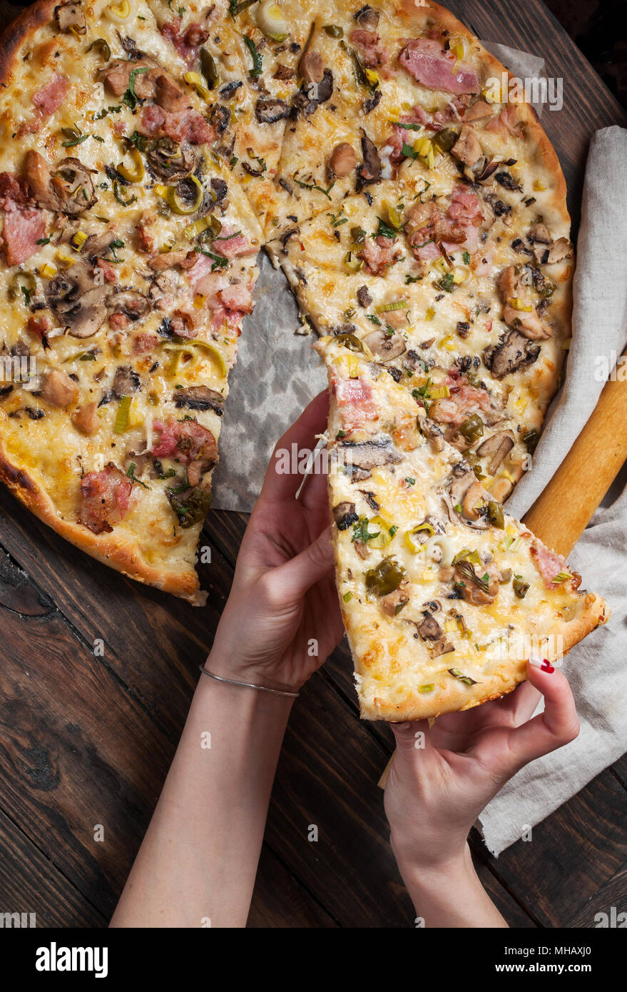 Hand taking single slice of Italian pizza Stock Photo - Alamy