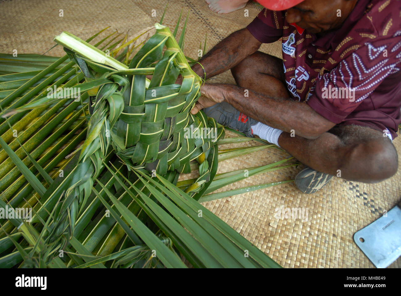 Fijian man creates a basket from weaving a Coconut Palm leaves, Pacific ...