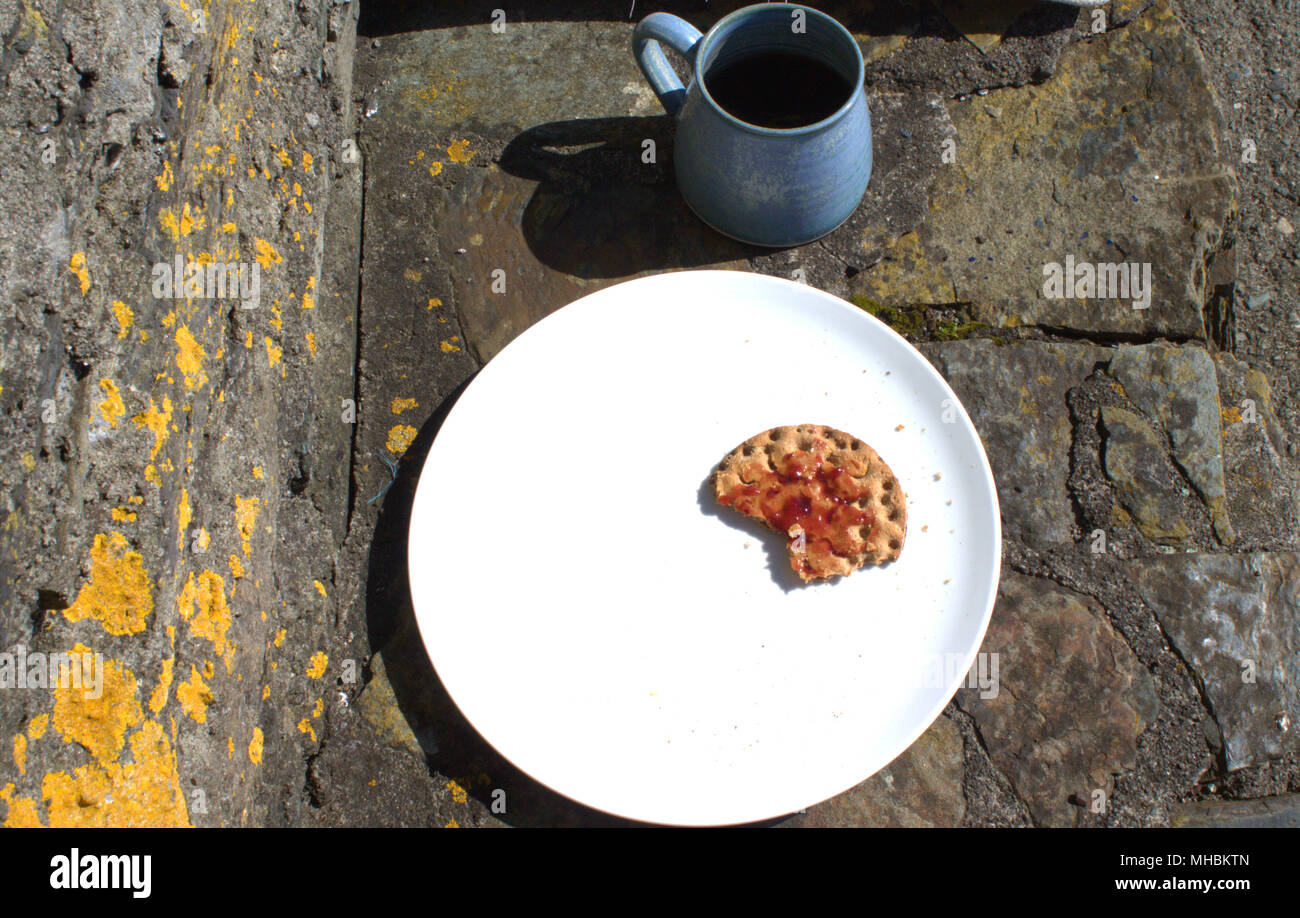 mid morning outdoor coffee and biscuit snack in the sun on a stone ...
