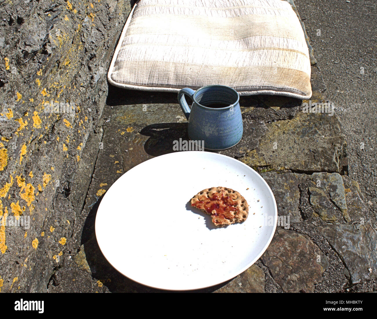 mid morning outdoor coffee and biscuit snack in the sun on a stone ...