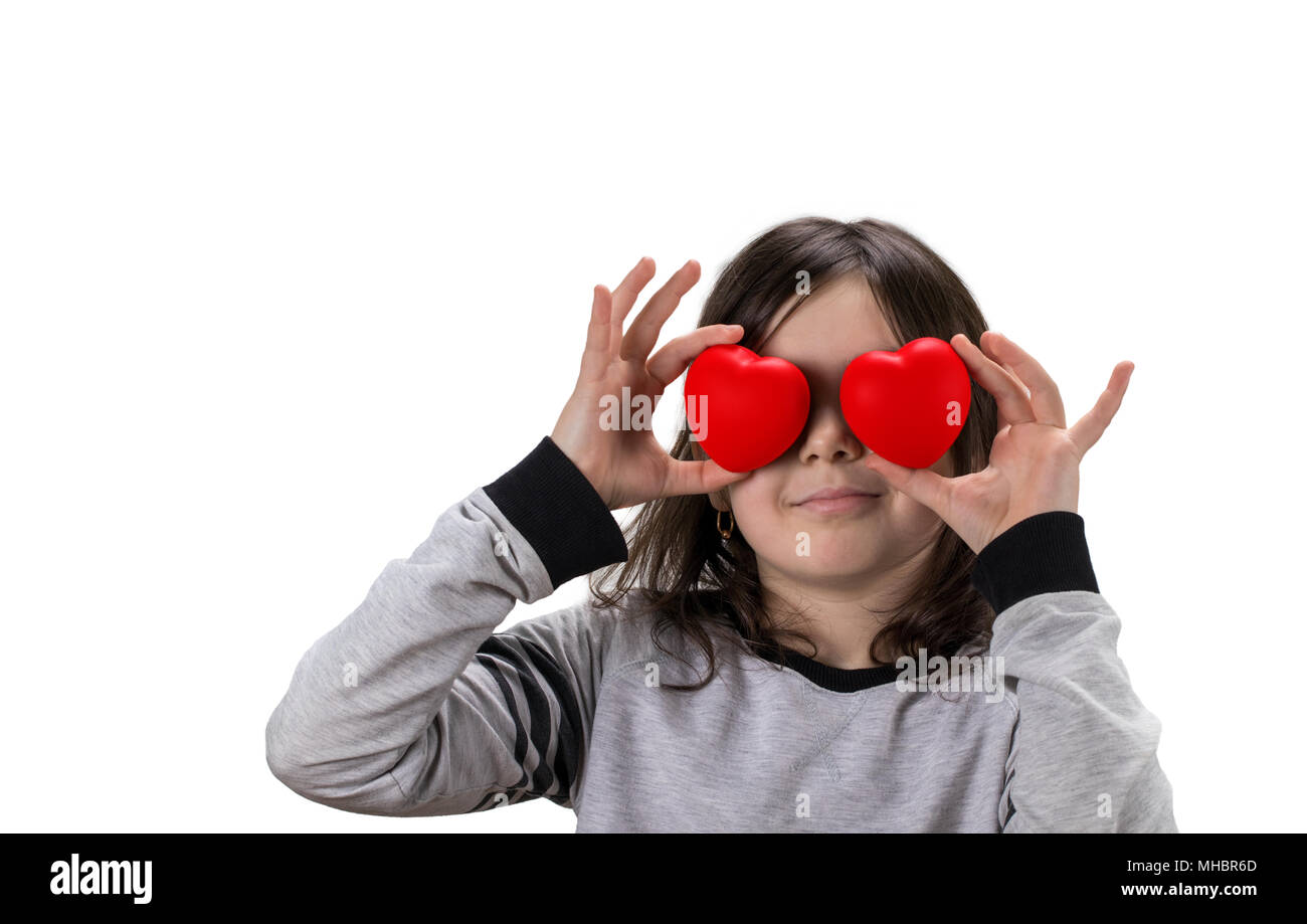 This is love! girl holding heart in front of his eyes and smiling while ...
