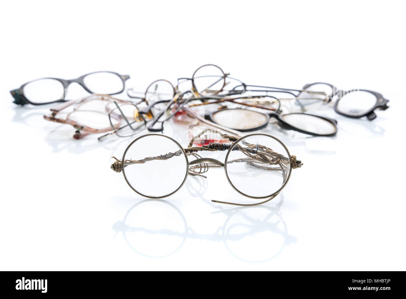 Old broken eyeglasses isolated on white background, with shadows and ...