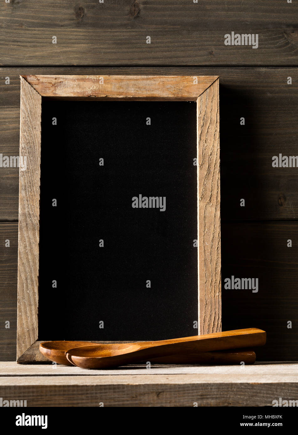 Wooden kitchen cooking tools in front of rustic wooden board background ...
