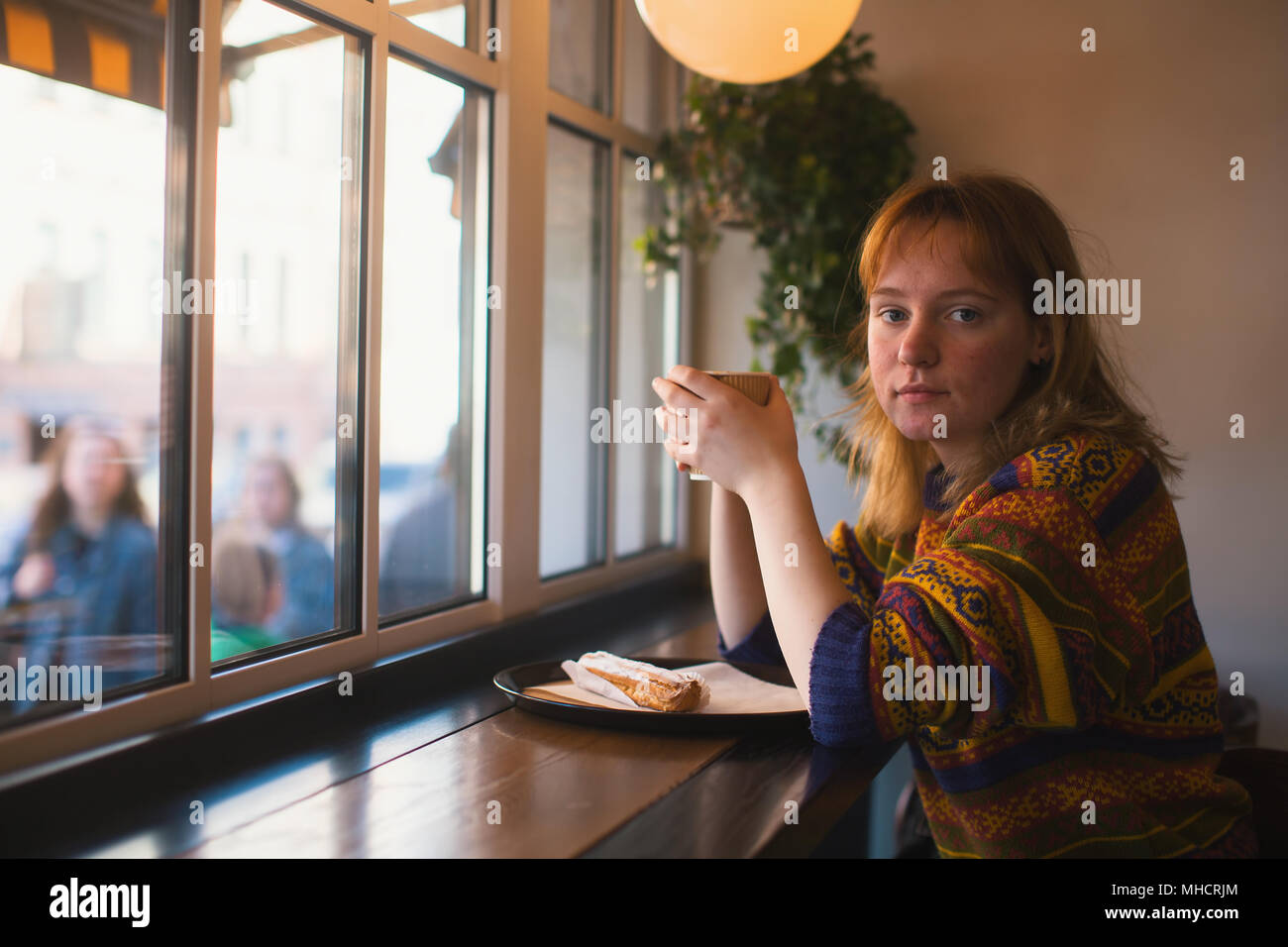 Girl sitting in a cafe near the window Stock Photo - Alamy
