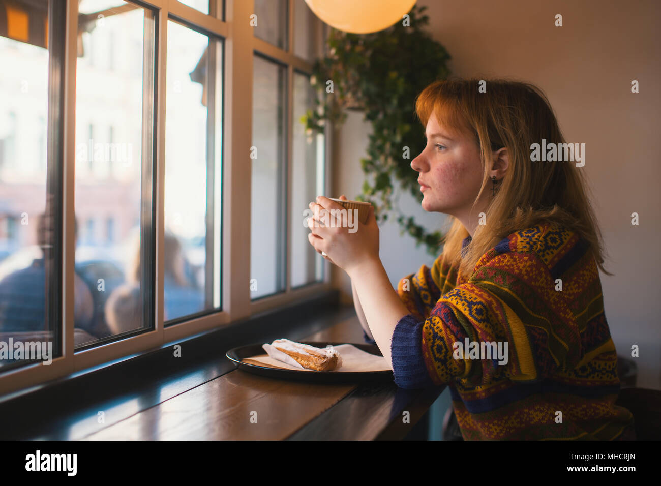 Girl sitting in a cafe near the window Stock Photo - Alamy
