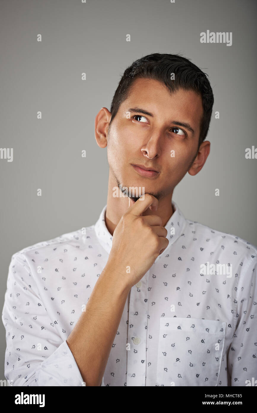 Young hispanic thinking man portrait isolated on gray background Stock ...