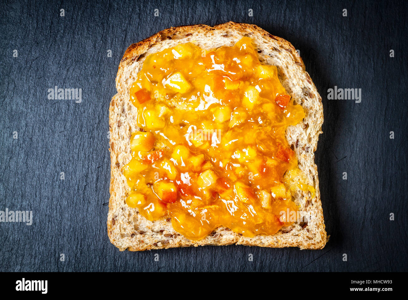 Orange marmalade on a slice of brown bread Stock Photo - Alamy