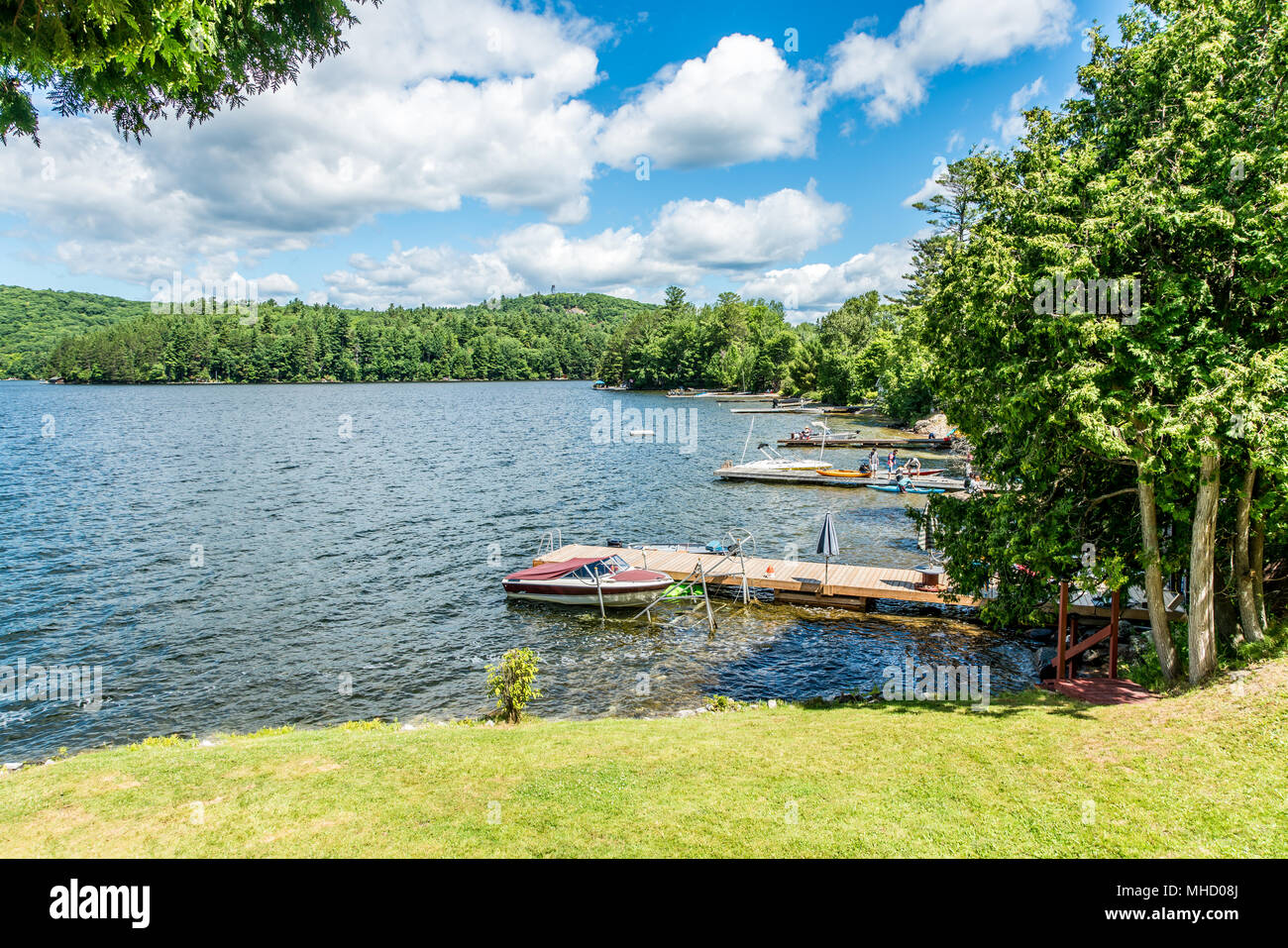 Lake side scenic landscape of boats and people preparing for kayaking ...