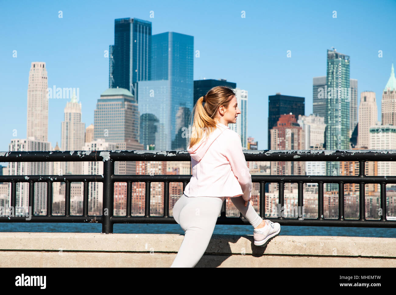 Athletic young woman stretching legs before run in New York Stock Photo ...