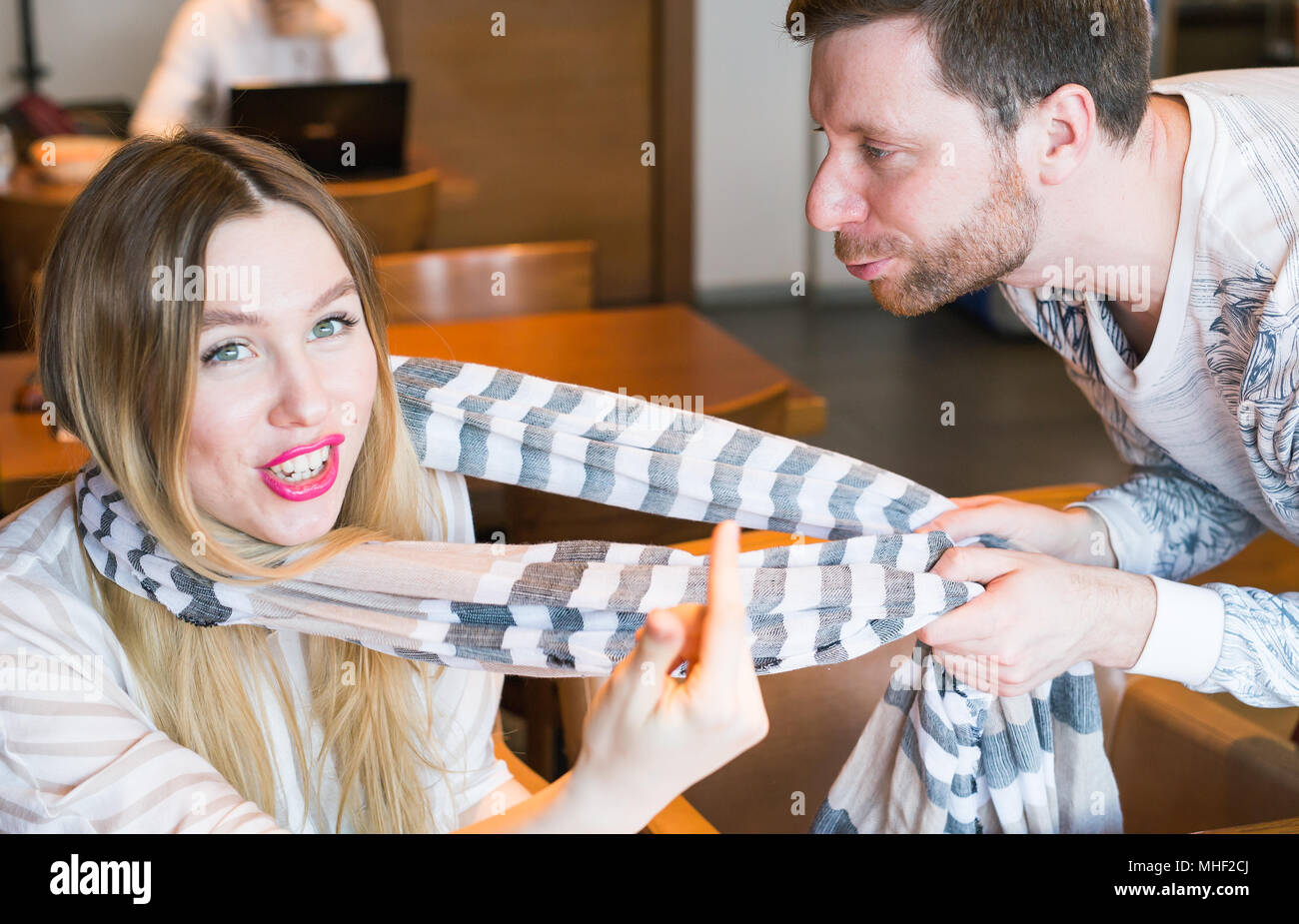 Funny handsome man pulling his girlfriend by scarf next to his - Love ...