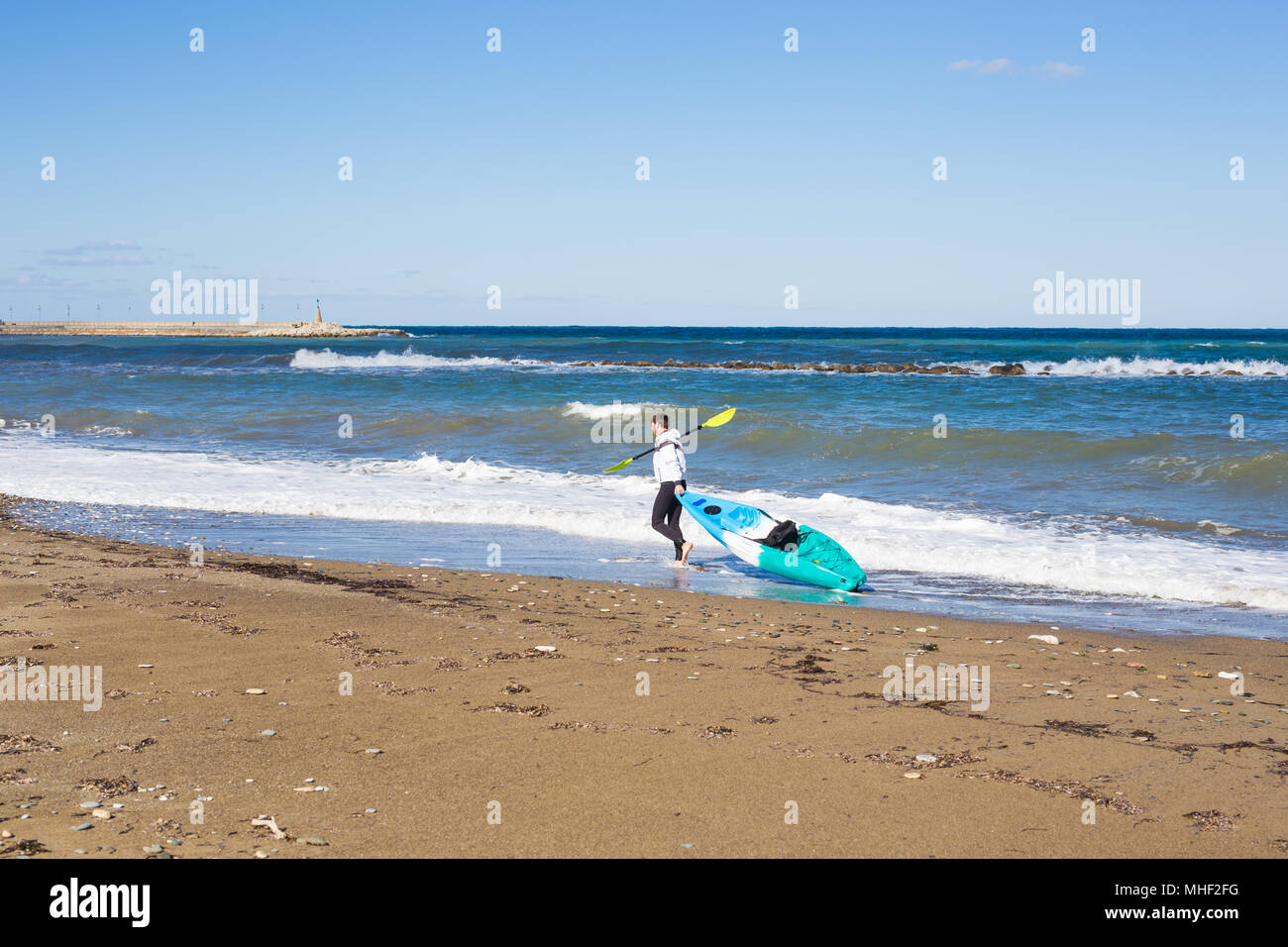 man carrying kayak at sea beach Stock Photo - Alamy