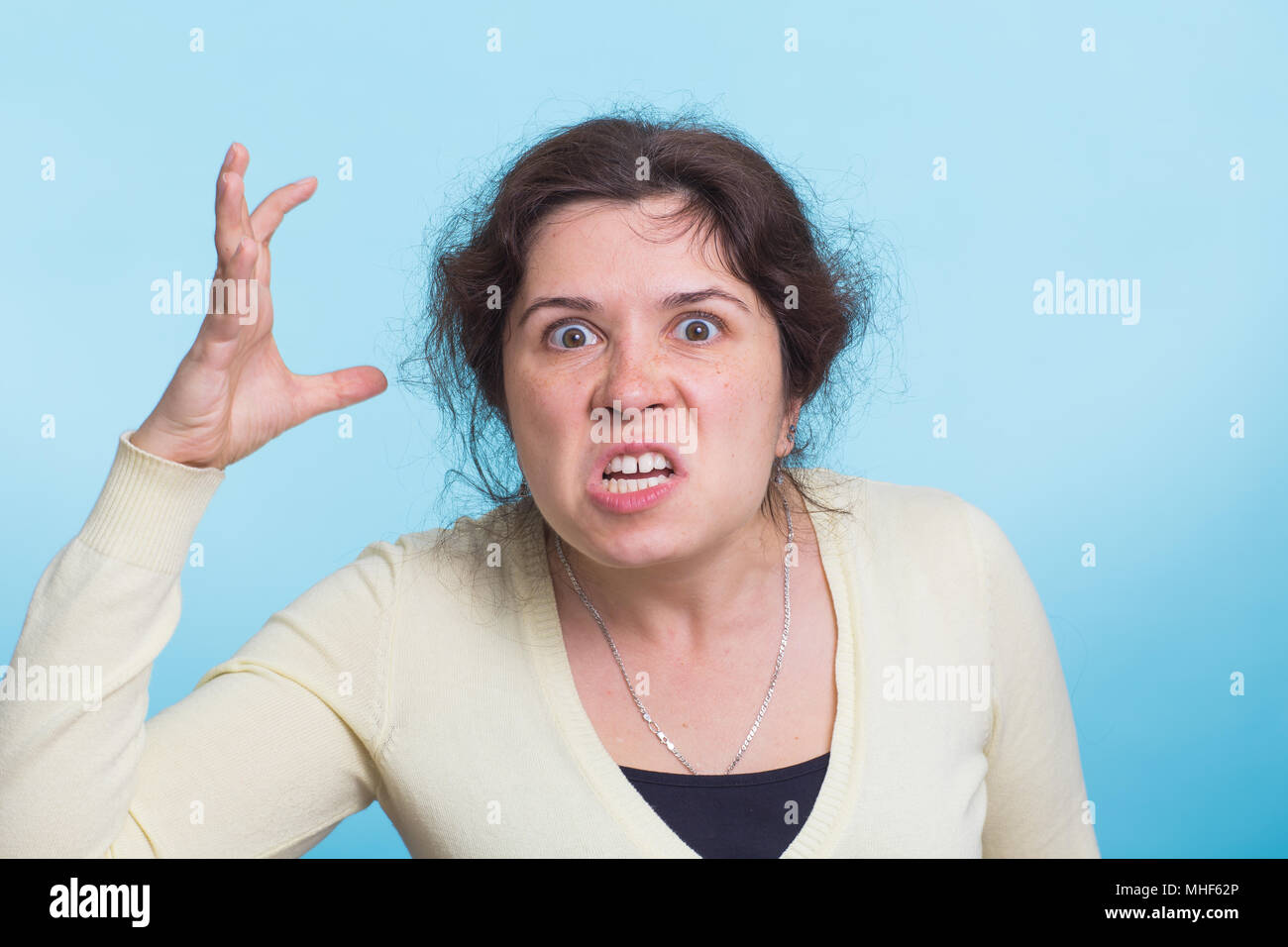 Angry aggressive woman on blue background Stock Photo - Alamy