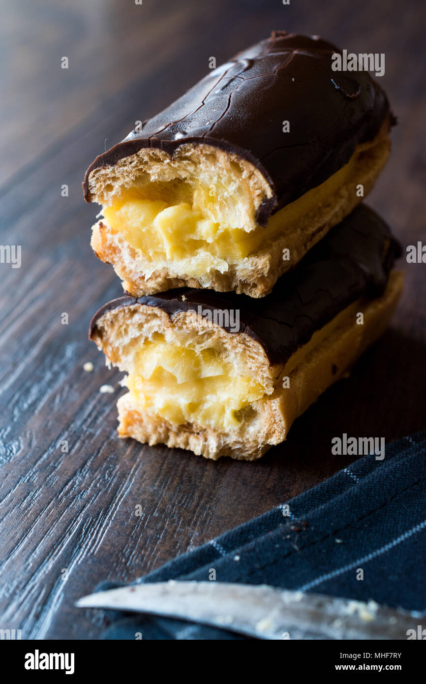 Half Cut Cream Filled Chocolate Eclairs on Dark Wooden Surface. Dessert ...