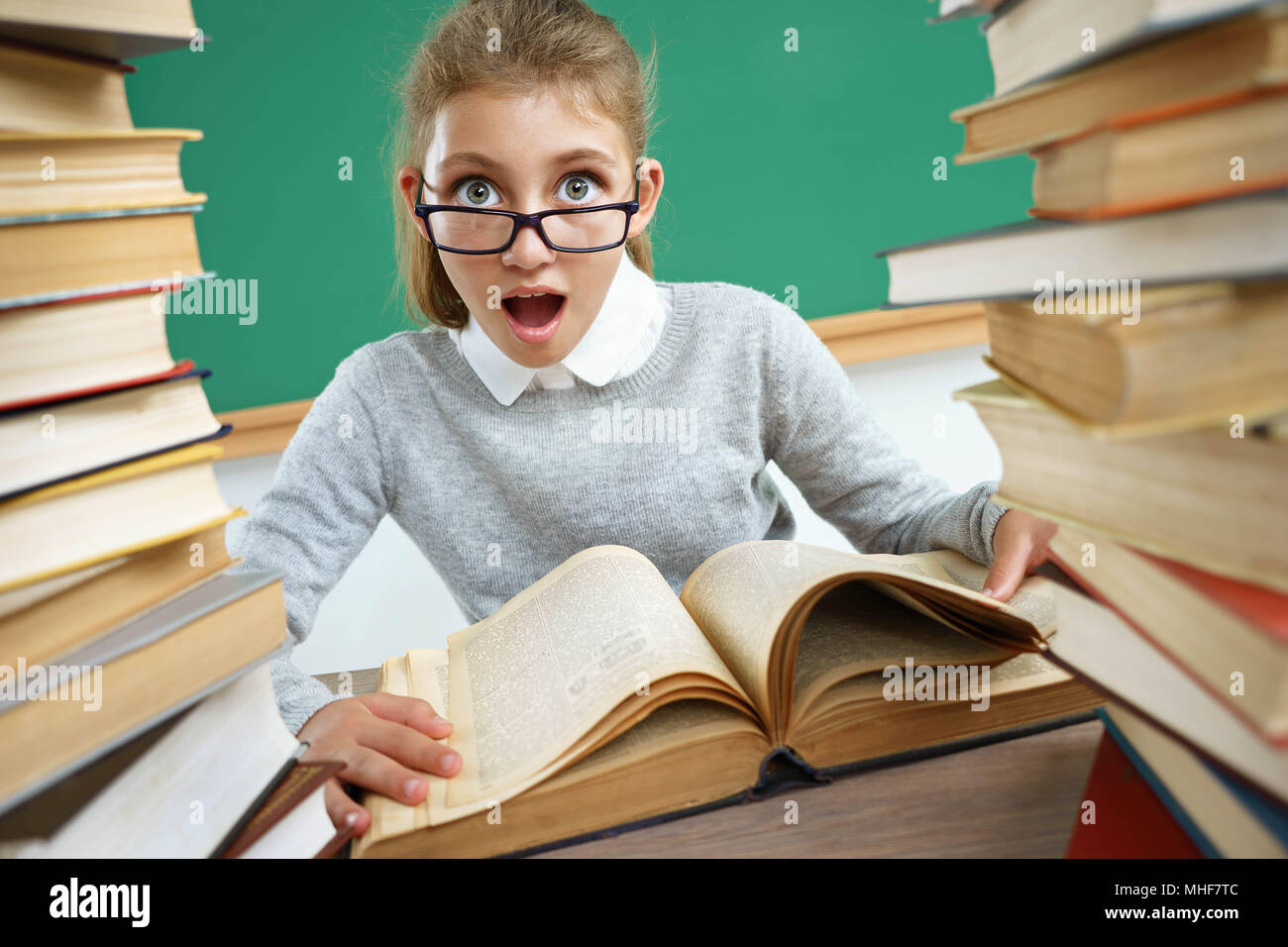 Schoolgirl with open mouth look at camera. Photo of little girl sitting ...