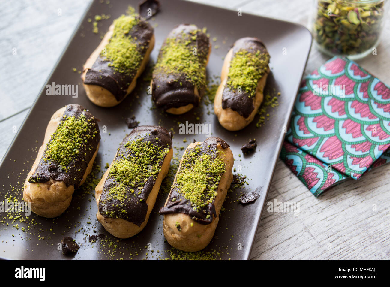 Chocolate Eclairs / Donut with pistachio powder Stock Photo - Alamy