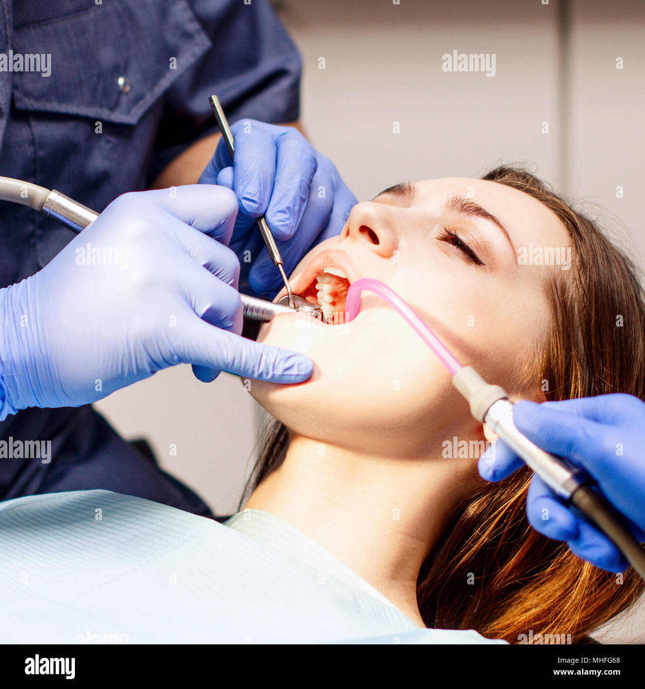 Male dentist treating teeth to young woman patient in clinic Stock ...