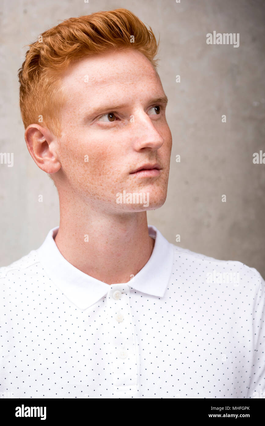 Closeup portrait of a young male model with red hair. Outdoor portrait ...