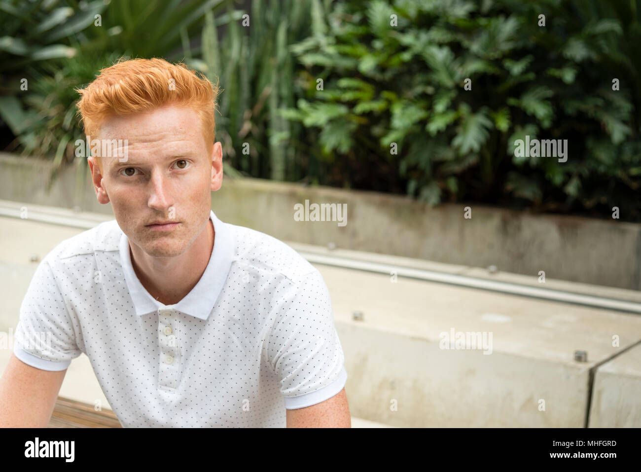 Closeup portrait of a young male model with red hair. Outdoor portrait ...