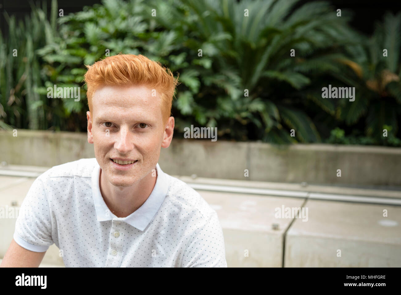 Closeup portrait of a young male model with red hair. Outdoor portrait ...