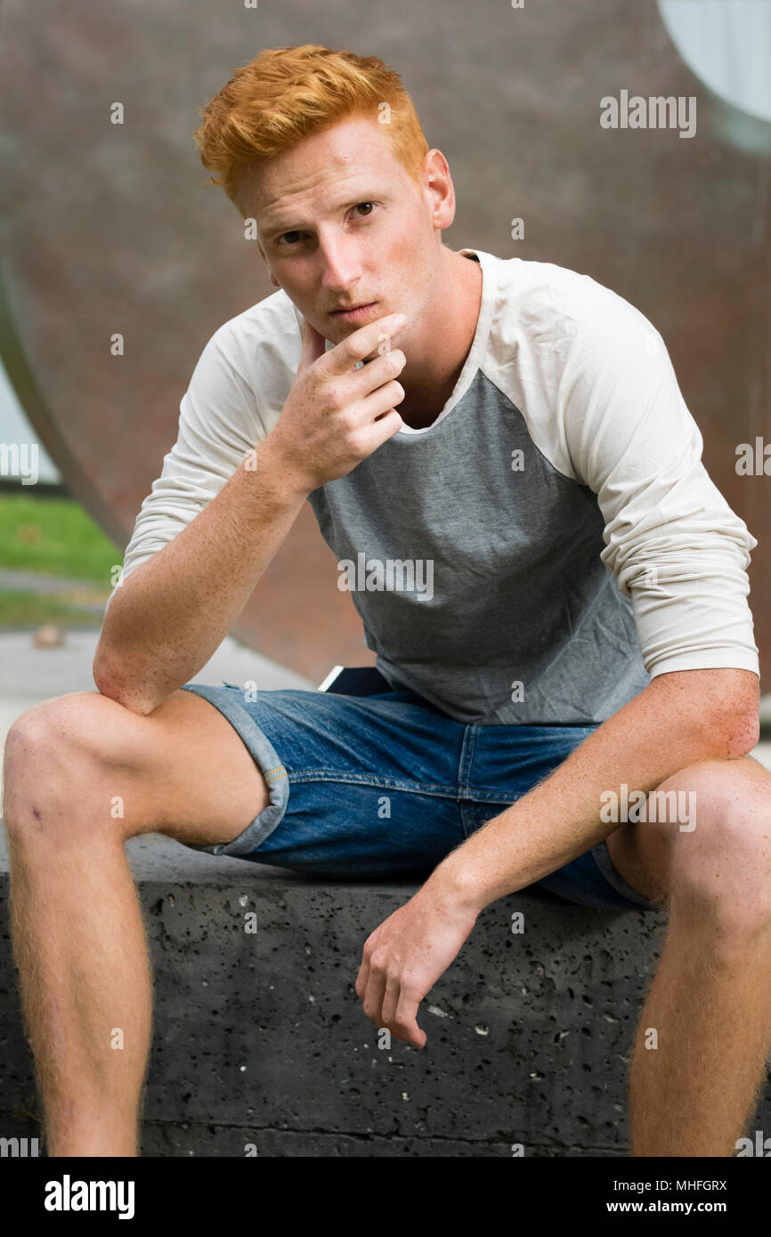 Portrait of a young male model with red hair. Outdoor portrait of a ...