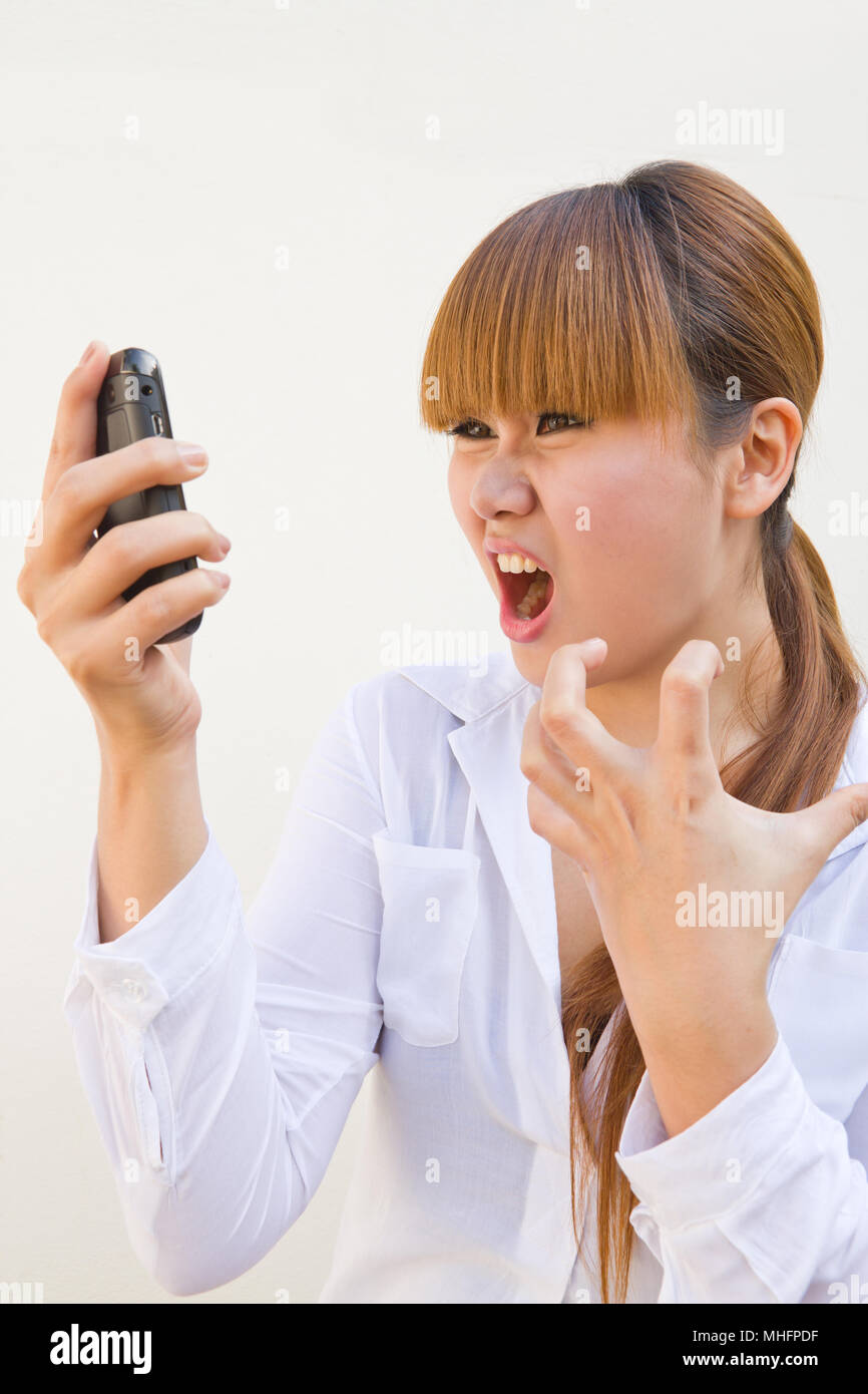 brunette woman screaming at phone Stock Photo - Alamy