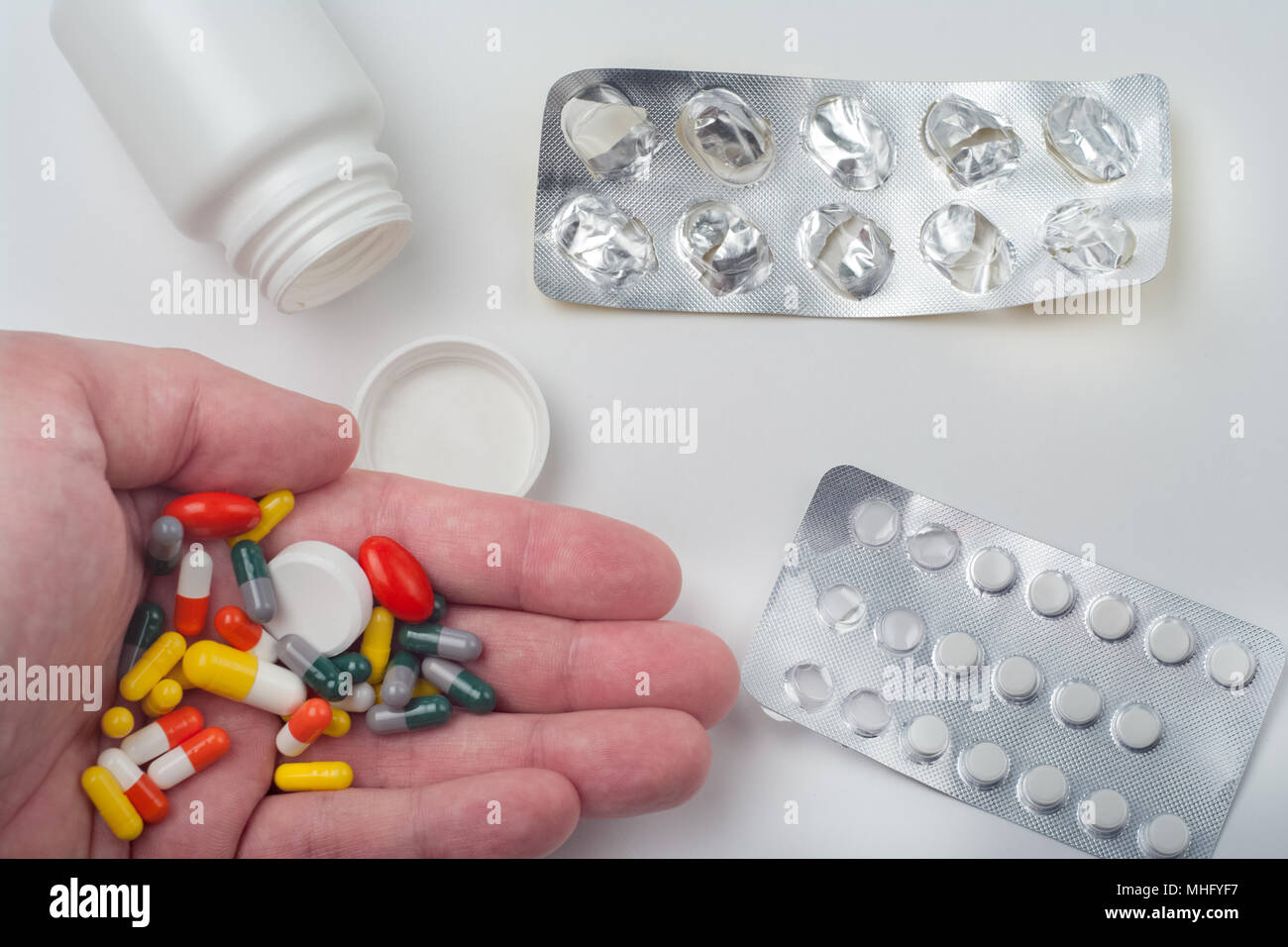 Drugs in hand on white background with medicine bottle, blister pack ...