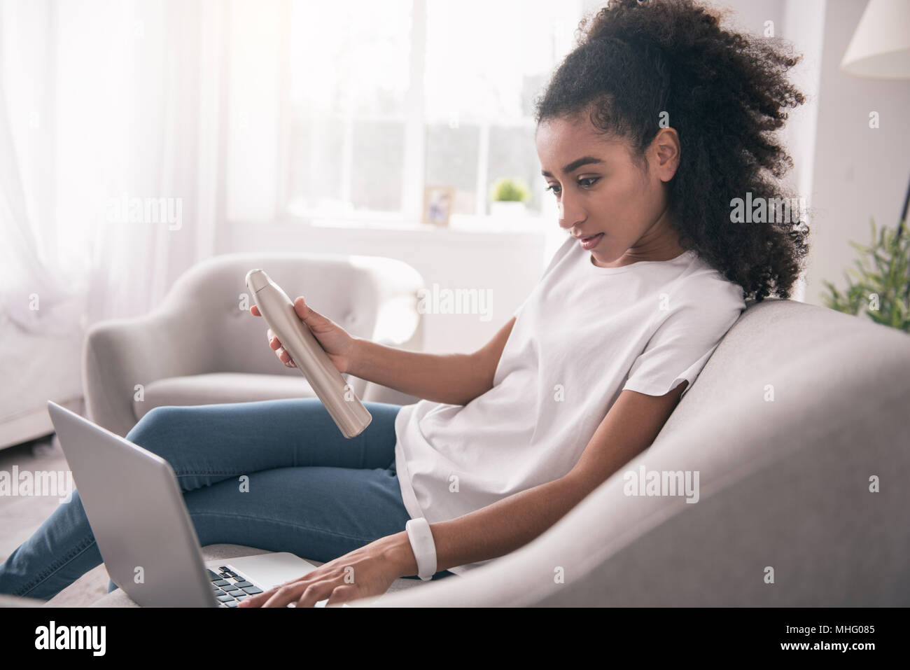 Pleasant young woman reading the reviews Stock Photo - Alamy