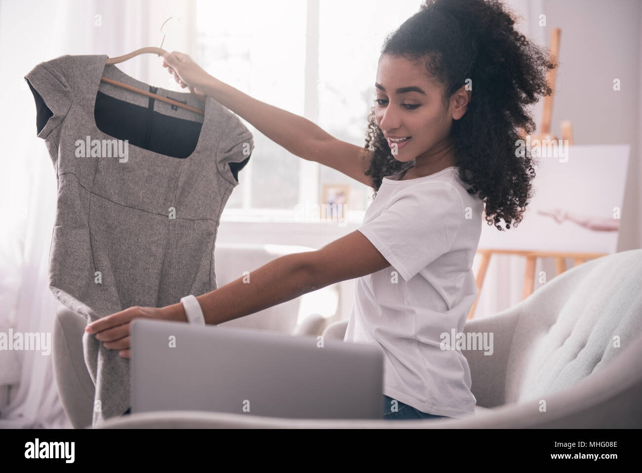 Positive attractive woman showing her dress Stock Photo - Alamy