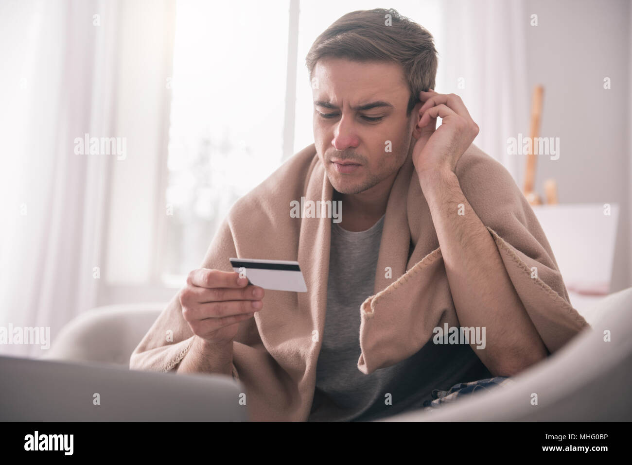 Sad sick man being covered in plaid Stock Photo - Alamy