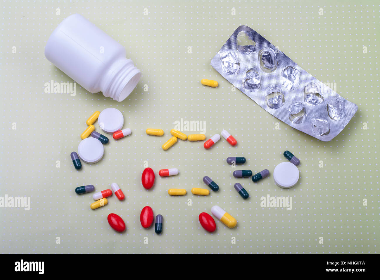Medicine bottle, blister pack and pills closeup on green background ...