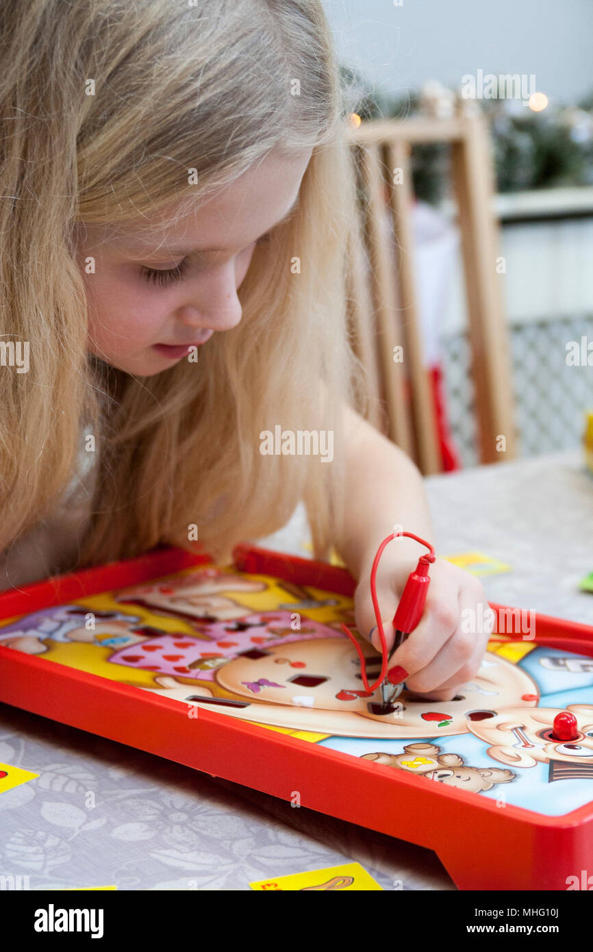 Child concentrating, girl kid playing the popular children's game ...