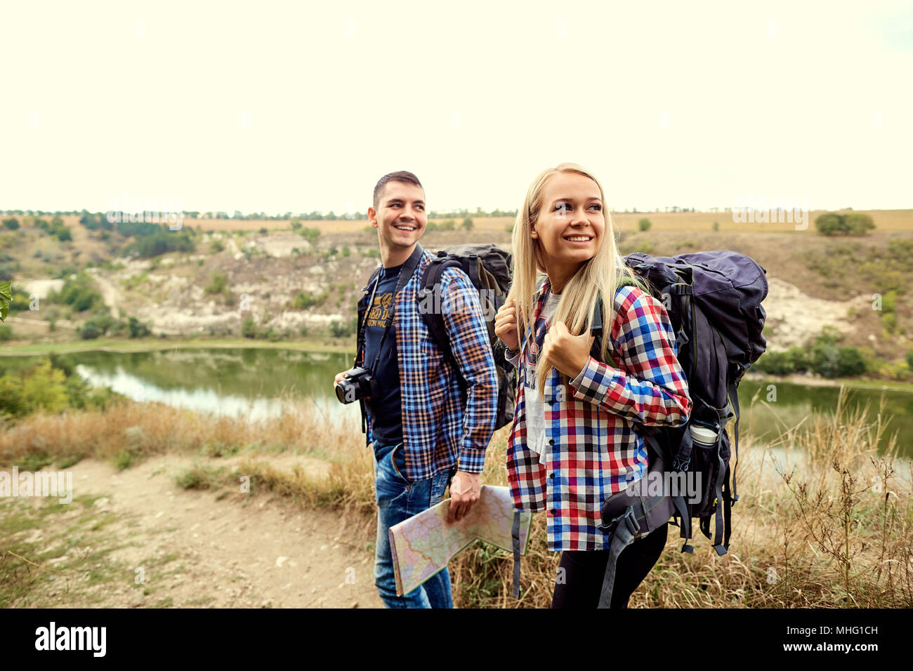 A young couple of tourists with a map in a hike in nature Stock Photo ...