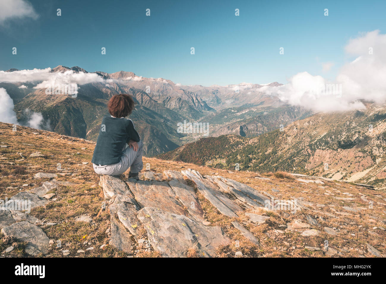 Hiker sitting on rock and looking at great panoramic view of the ...