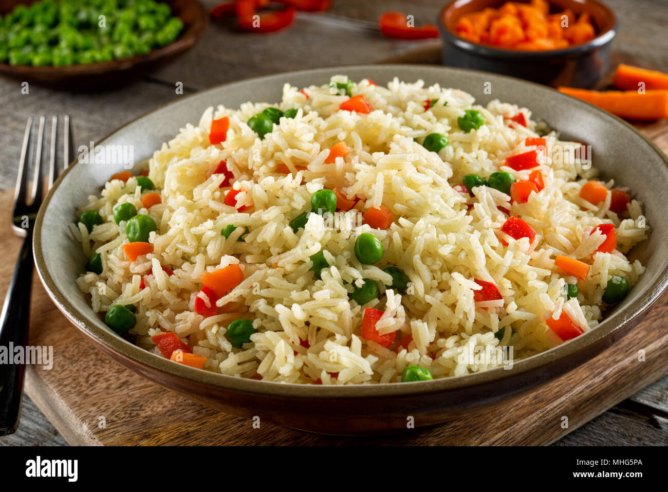 Delicious vegetable rice pilaf with green peas, carrots and red peppers ...