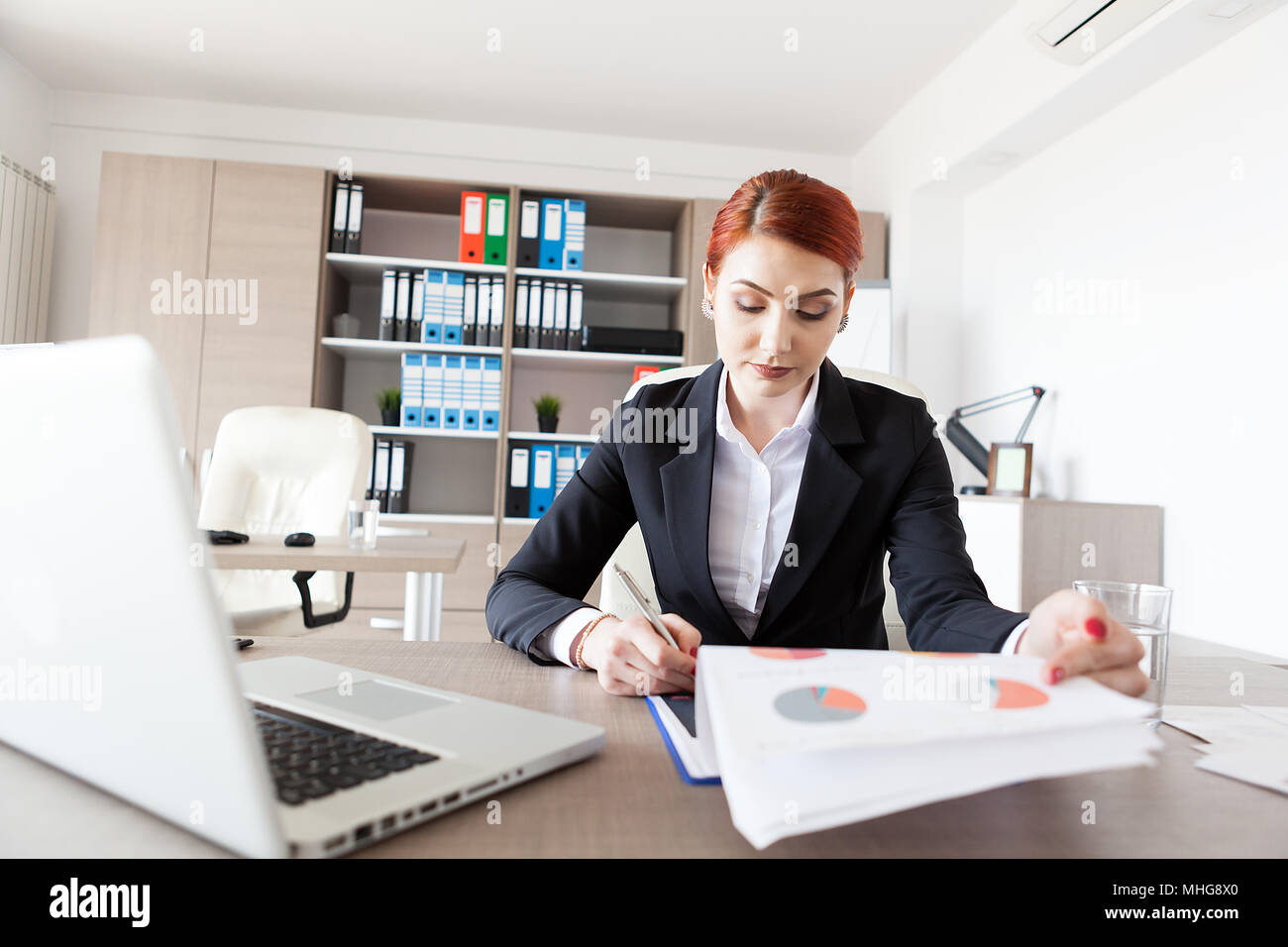 Wide angle image of young businesswoman looking at documents Stock ...
